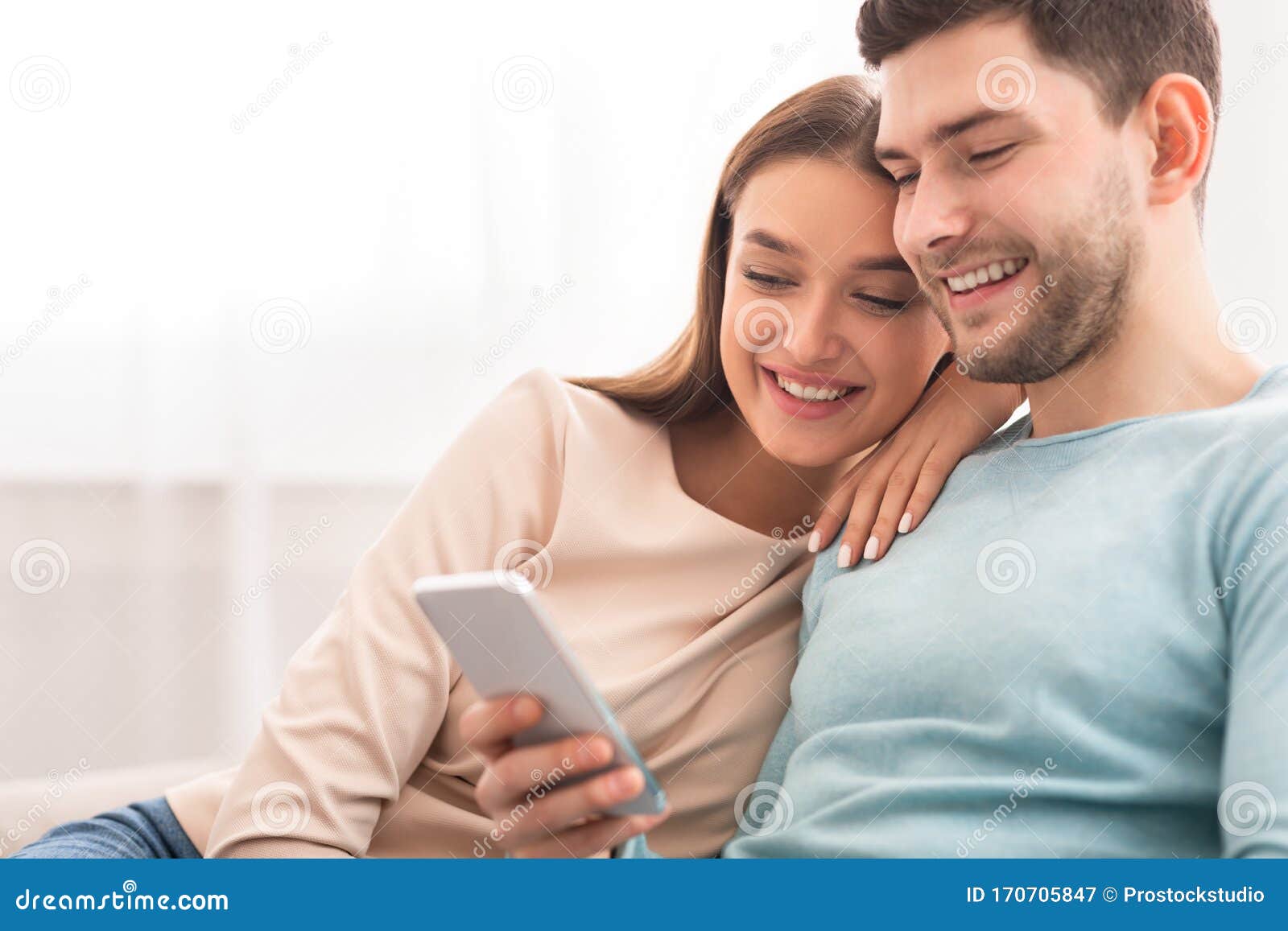 Happy Spouses Using Phone Sitting on Couch at Home Stock Image - Image ...