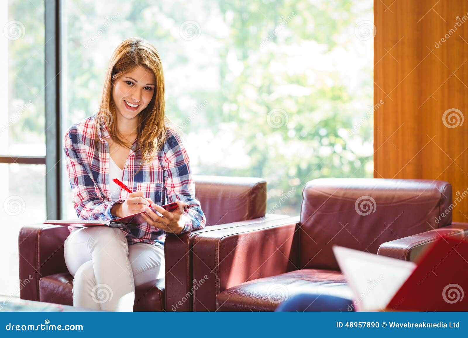 Happy Student Sitting on Couch Writing Smiling at Camera Stock Photo ...