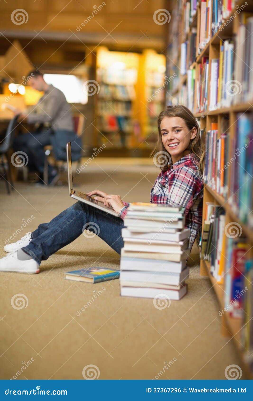 Happy Student Using Laptop on Library Floor Looking at Laptop Stock ...