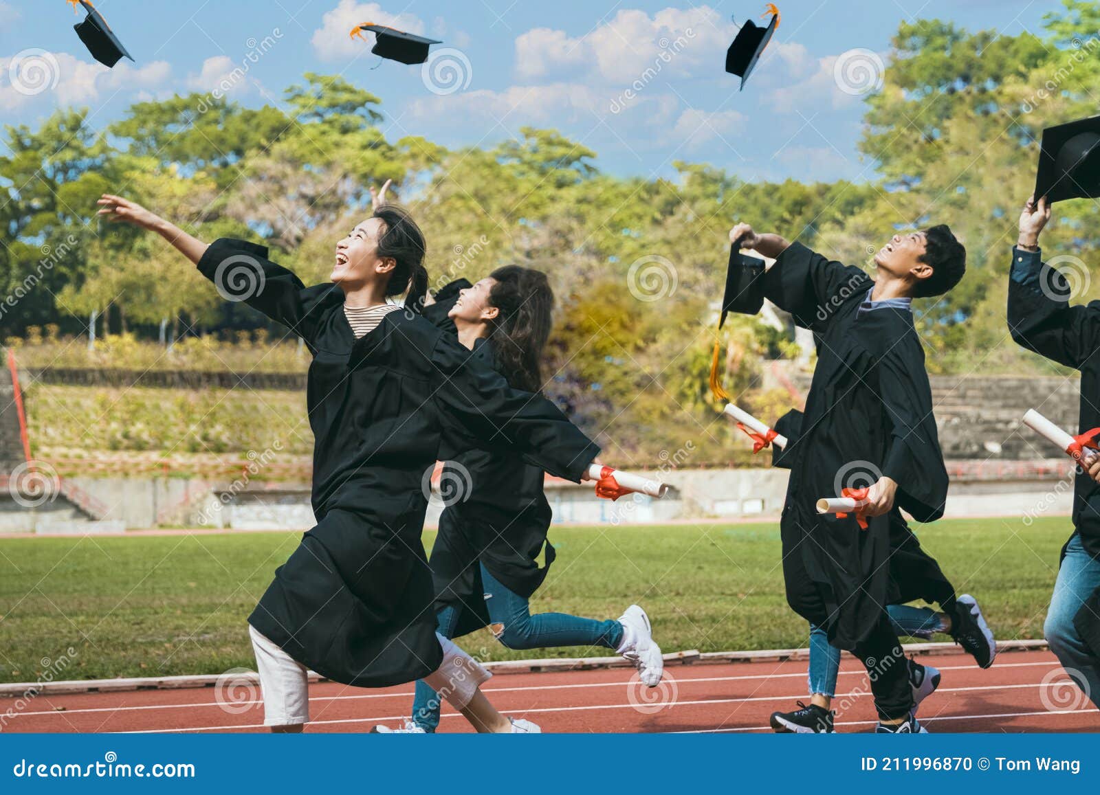 Happy Students with Congratulations Throwing Graduation Hats in the Air ...