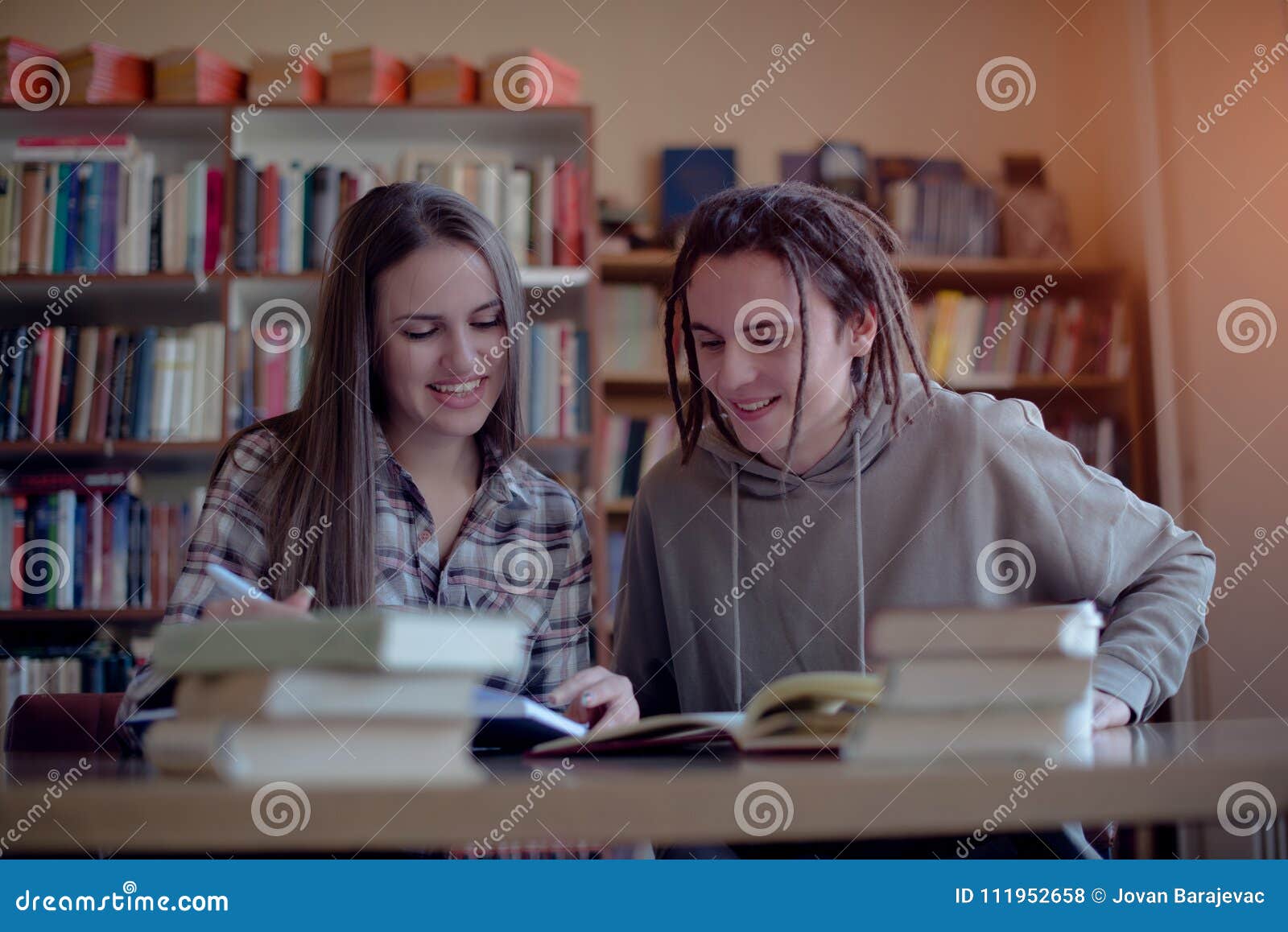 Happy students in library. stock photo. Image of females - 111952658