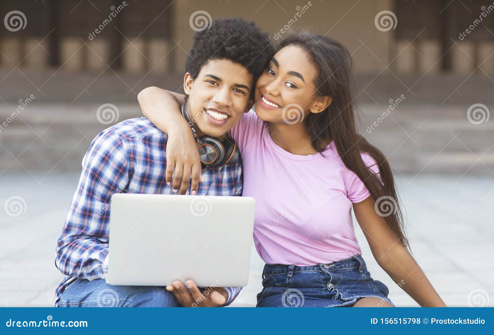 Happy Students Posing To Camera while Using Laptop Together Outdoors ...