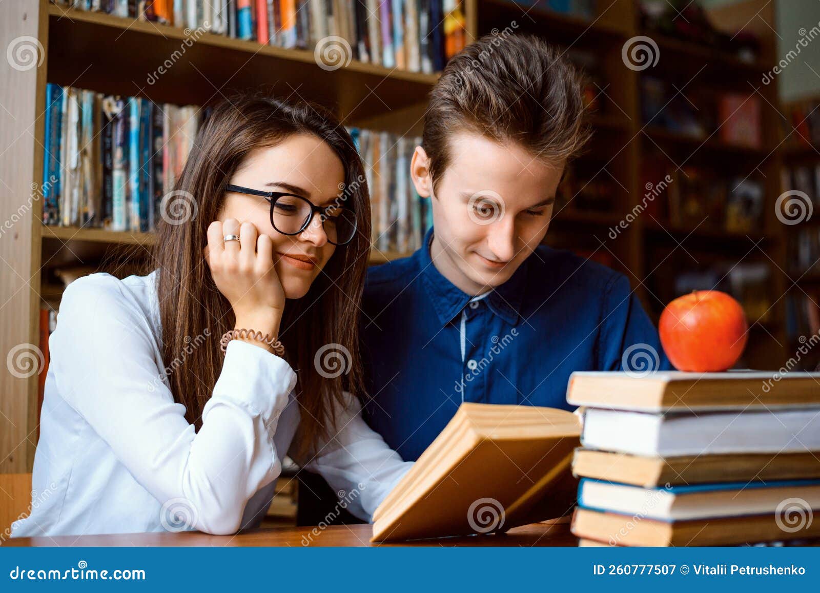 Happy Students Reading a Book in the Library Together Stock Image ...