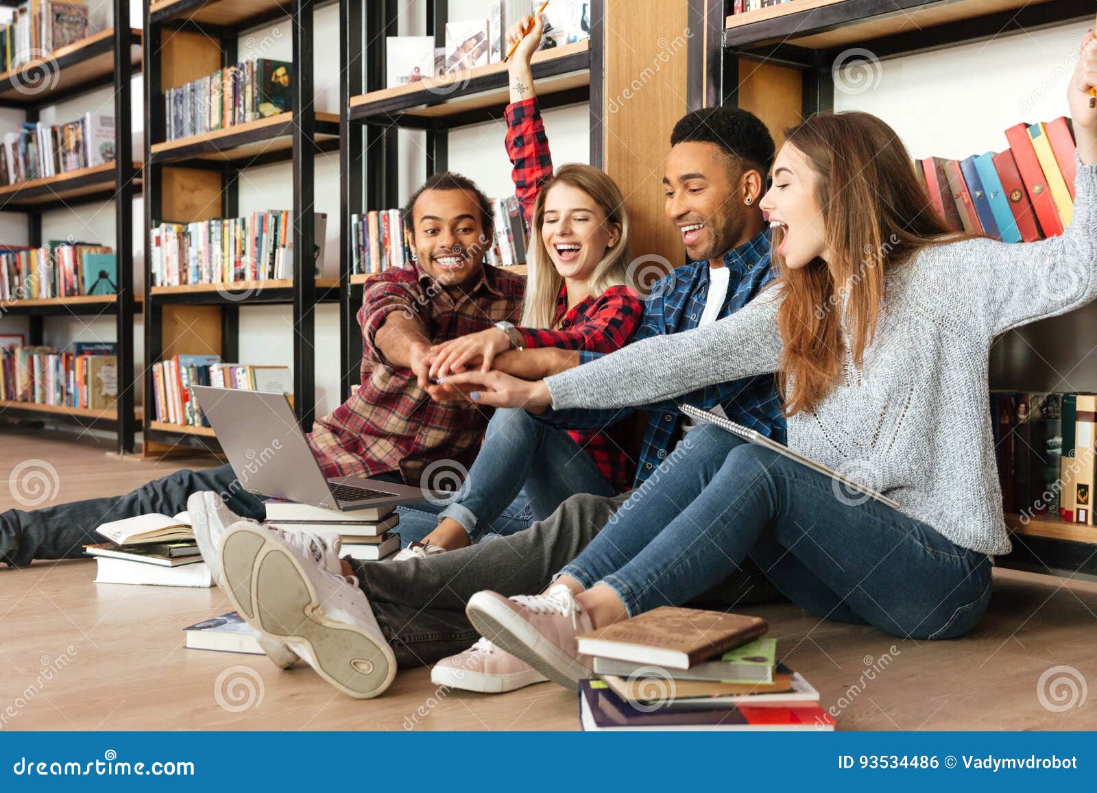 Happy Students Sitting in Library on Floor Using Laptop Computer Stock ...