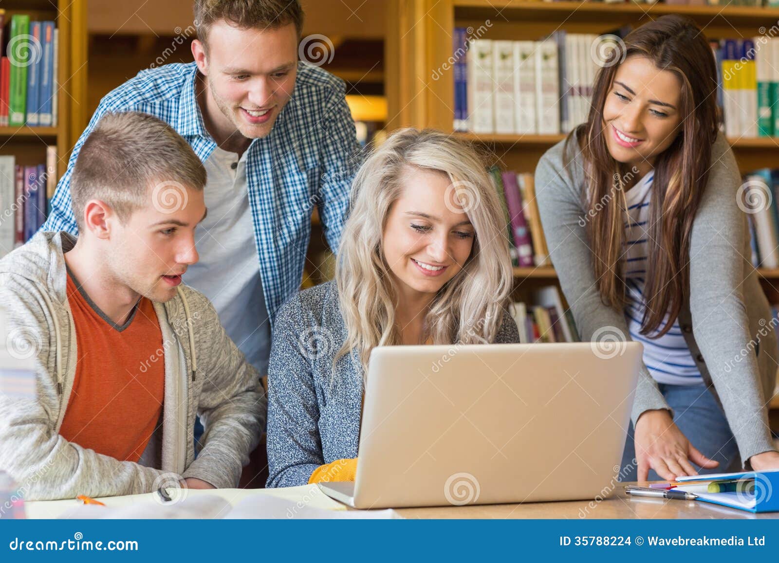 Happy Students Using Laptop at Desk in Library Stock Photo - Image of ...