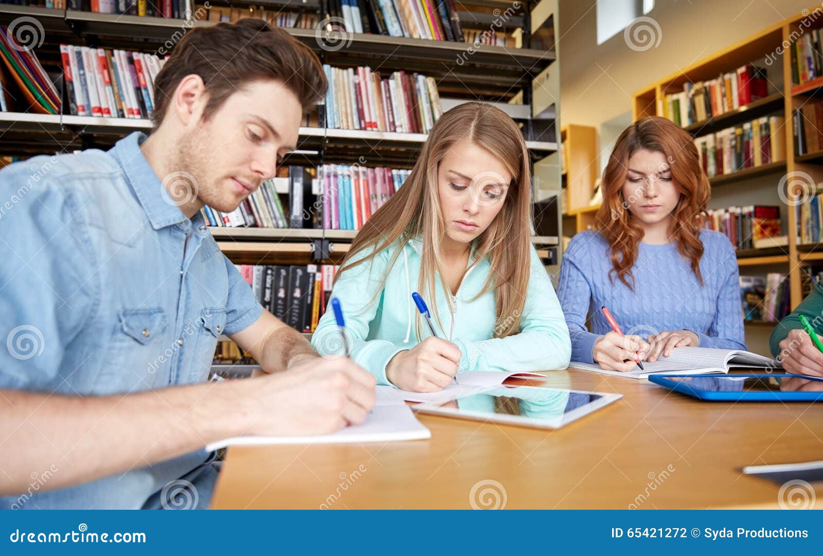 Happy Students Writing To Notebooks in Library Stock Photo - Image of ...