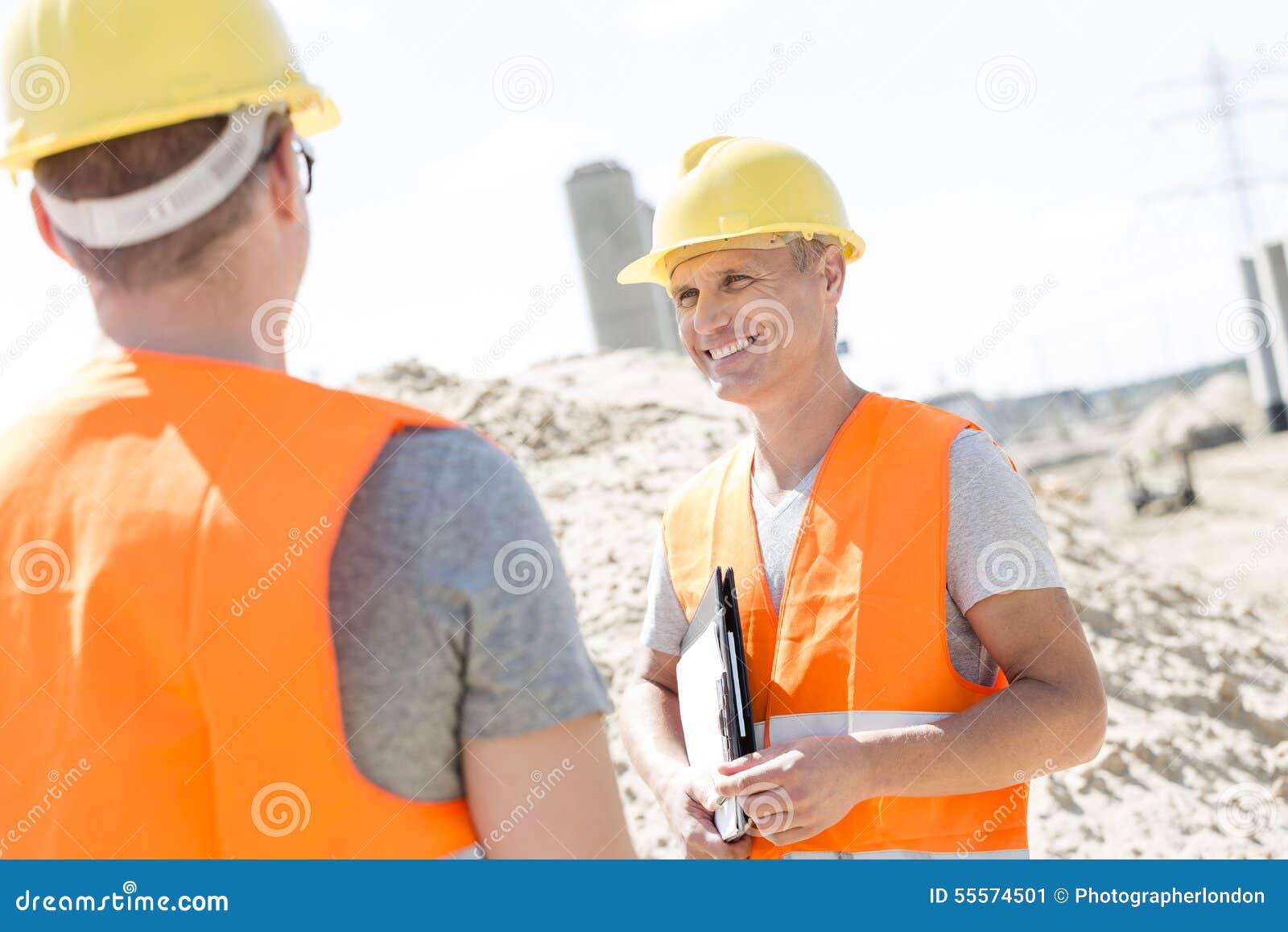 Happy Supervisor Discussing with Colleague at Construction Site Stock ...