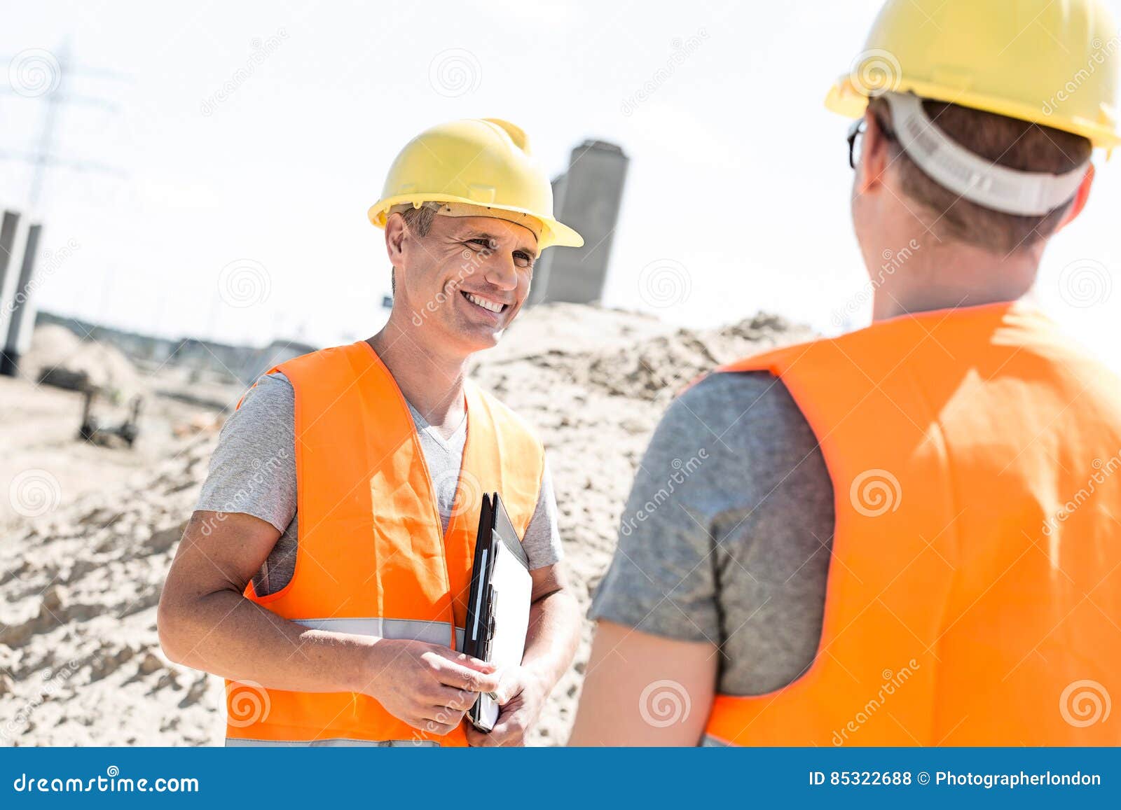 Happy Supervisor Discussing with Colleague at Construction Site Stock ...