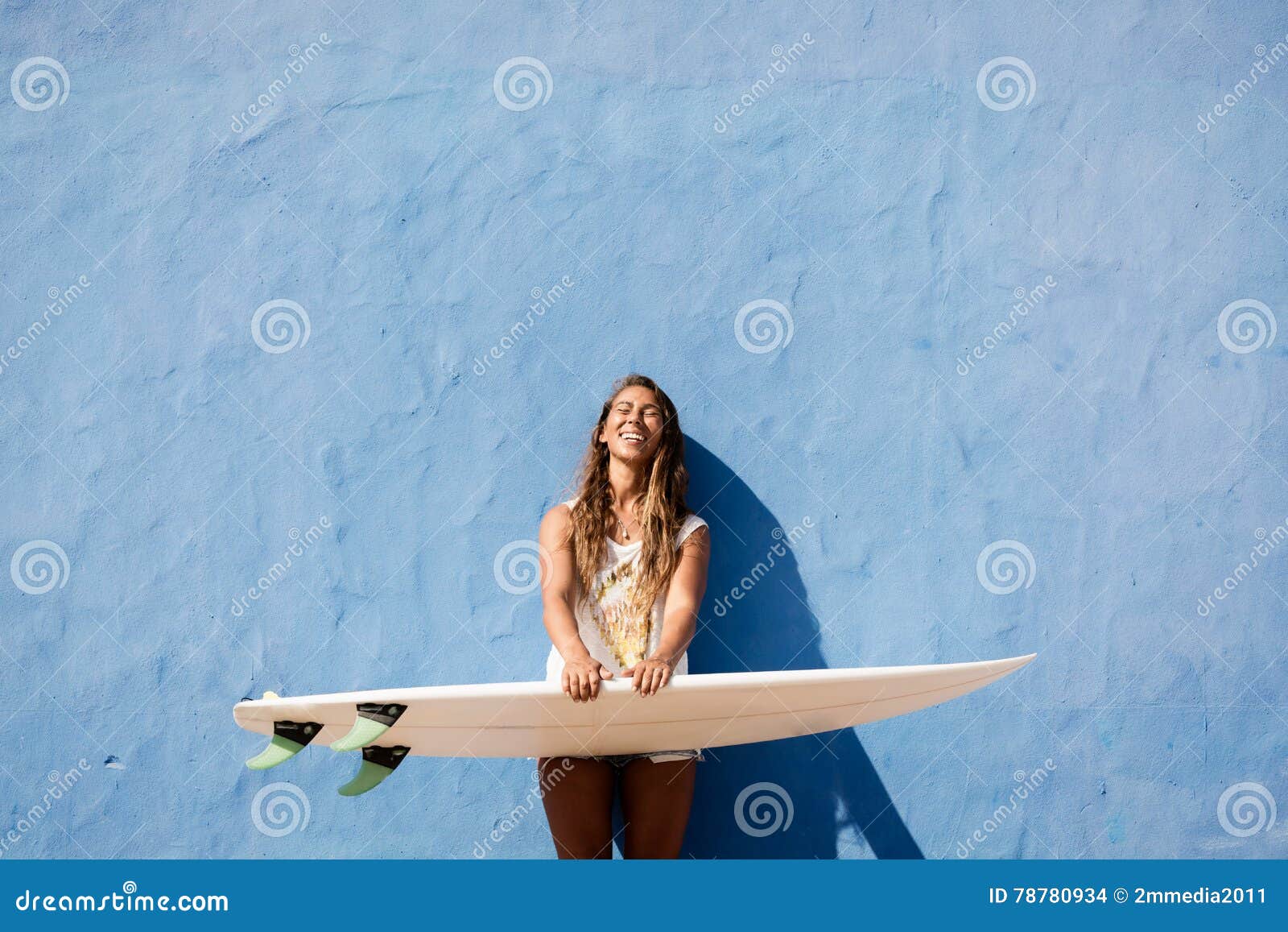 Happy Surfer Girl with Surfboard in Front of Blue Wall Stock Photo ...