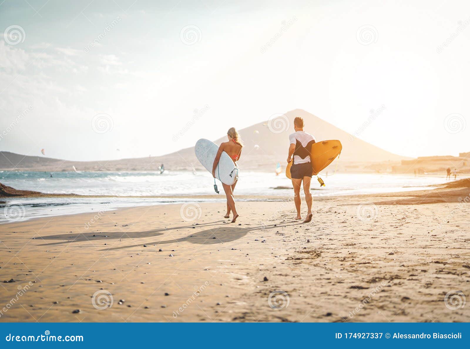Happy Surfers Running With Surfboards On The Beach Sporty Couple