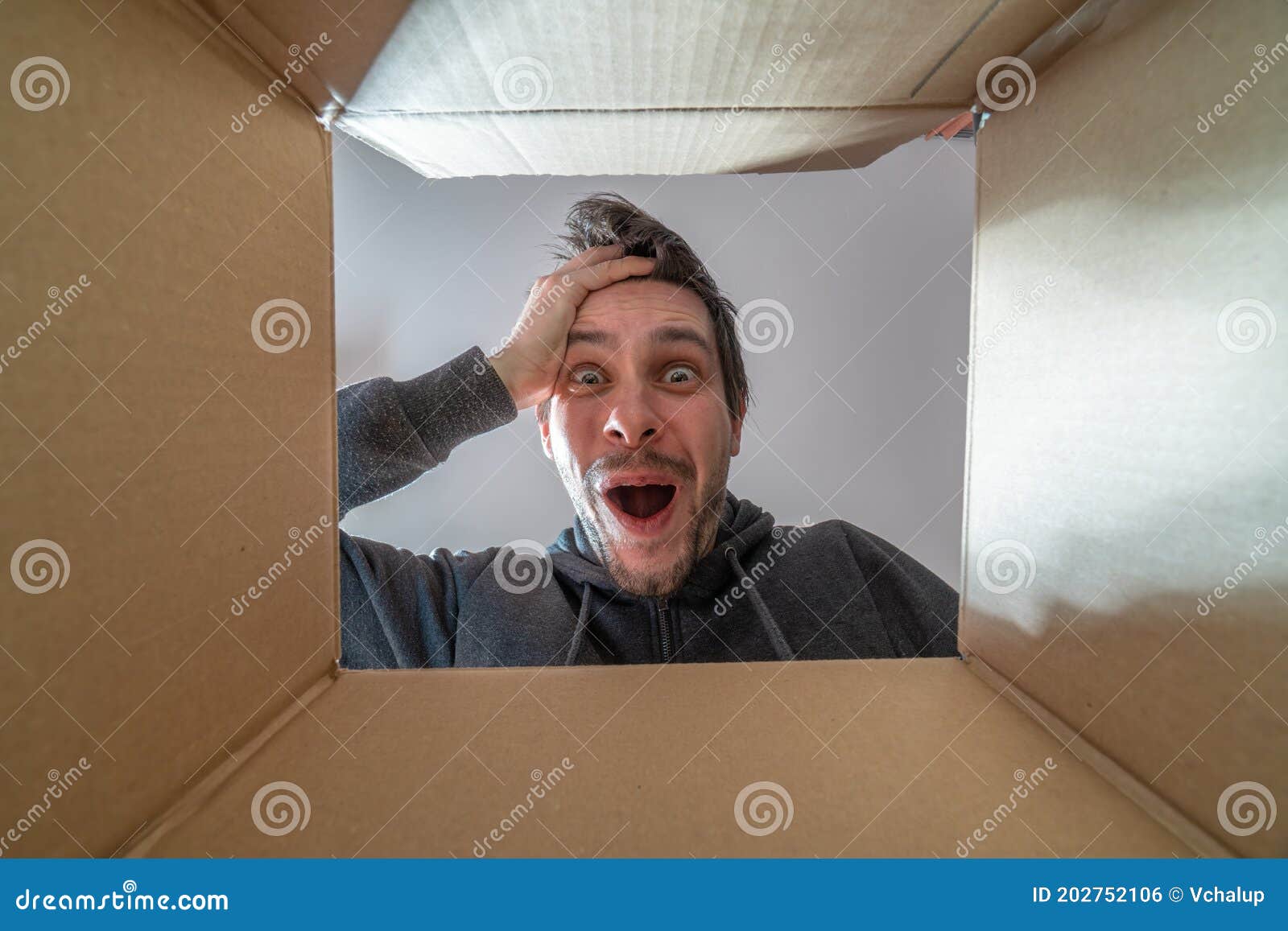 Happy and Surprised Man is Opening a Gift and Looking Inside Cardboard ...