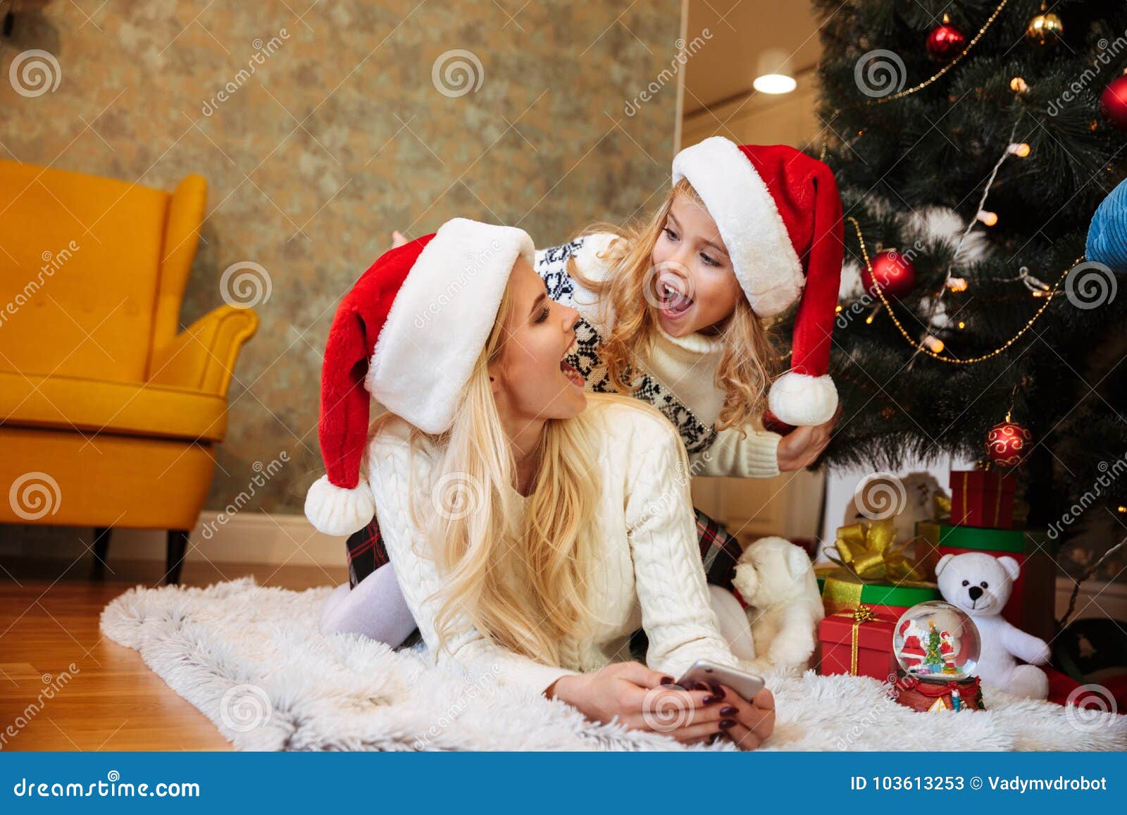 Happy Surprised Mother And Her Daughter In Santa`s Hat Looking A Stock