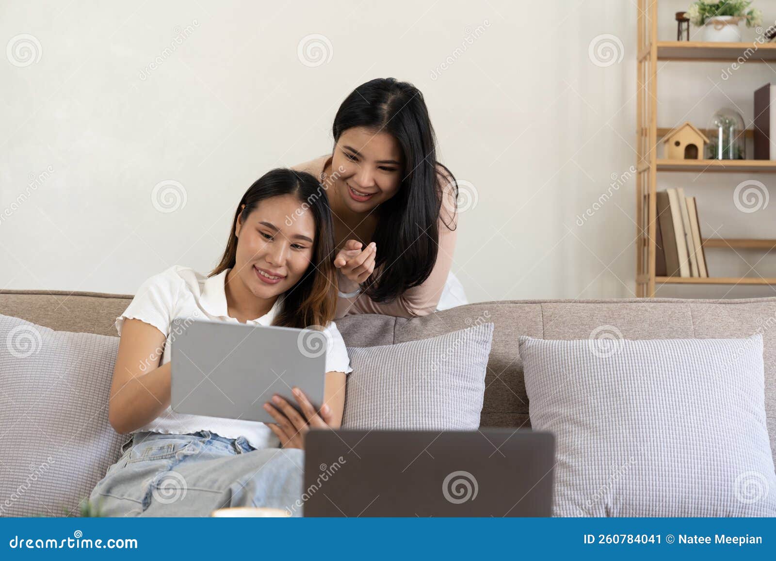 Happy Two Young Asian Girls are Sitting on Couch Using Digital Tablet ... Happy Two Young Asian Girls are Sitting on Couch Using Digital Tablet ...
