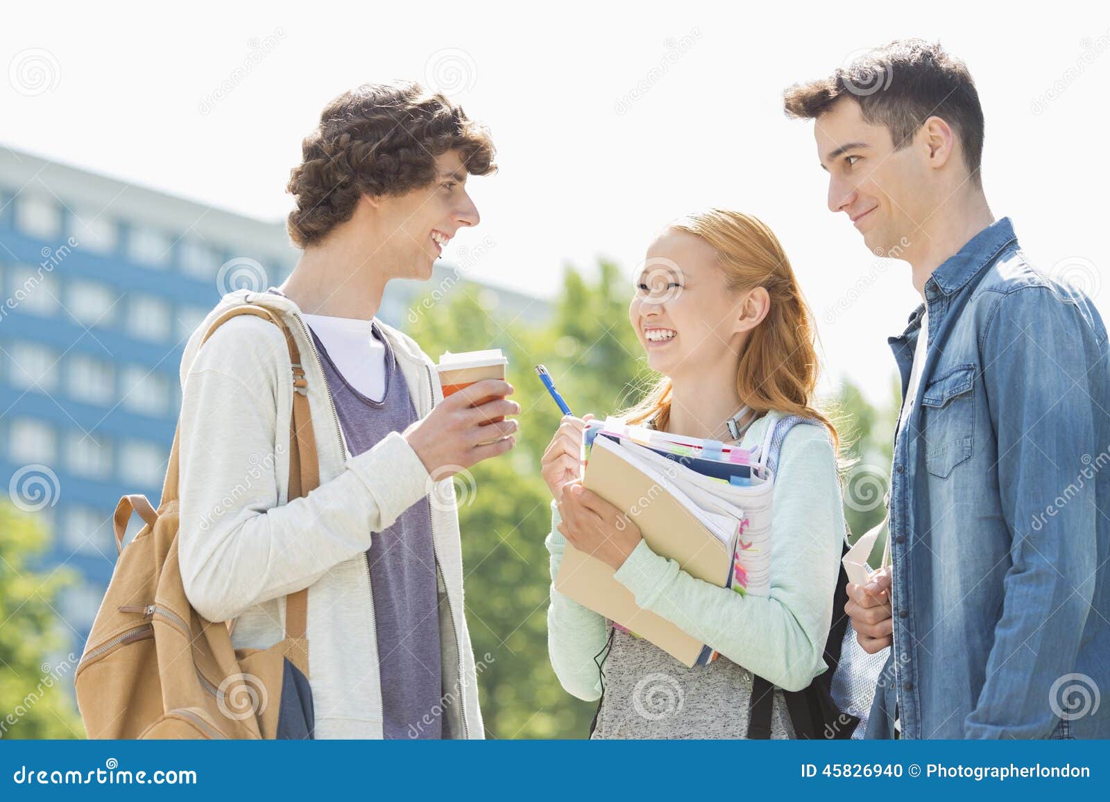 Happy University Students Conversing at Campus Stock Photo - Image of ...