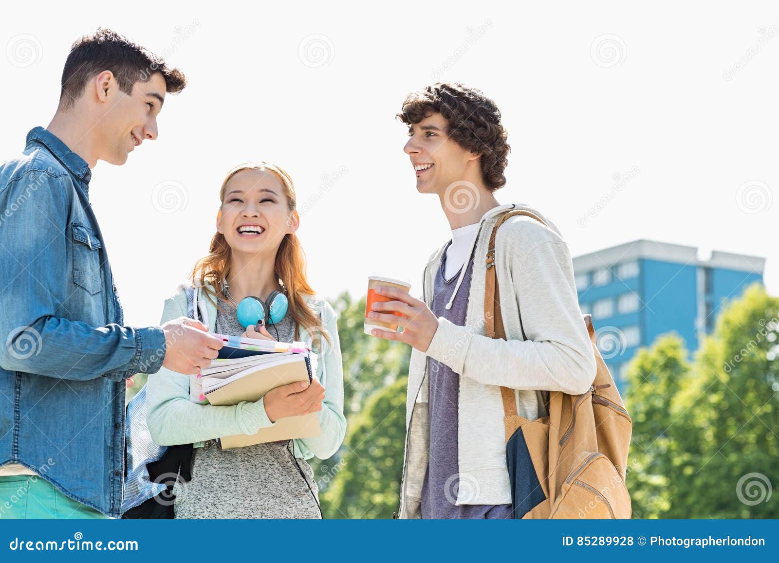 Happy University Students Conversing at Campus Stock Photo - Image of ...