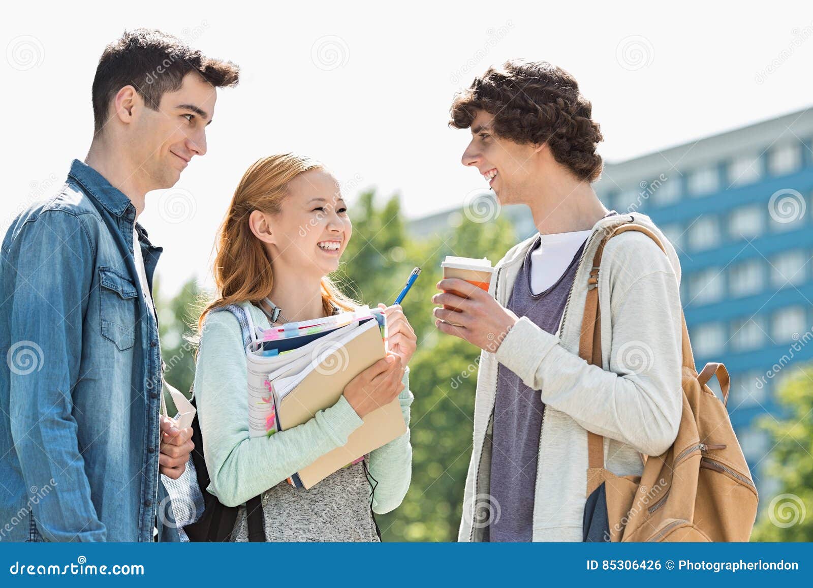 Happy University Students Conversing at Campus Stock Photo - Image of ...