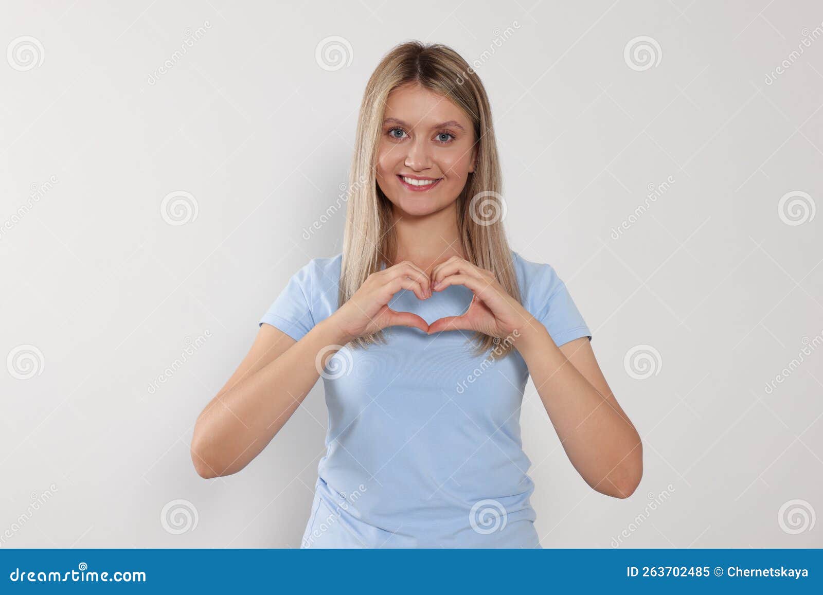 Happy Volunteer Making Heart with Her Hands on Light Background Stock ...