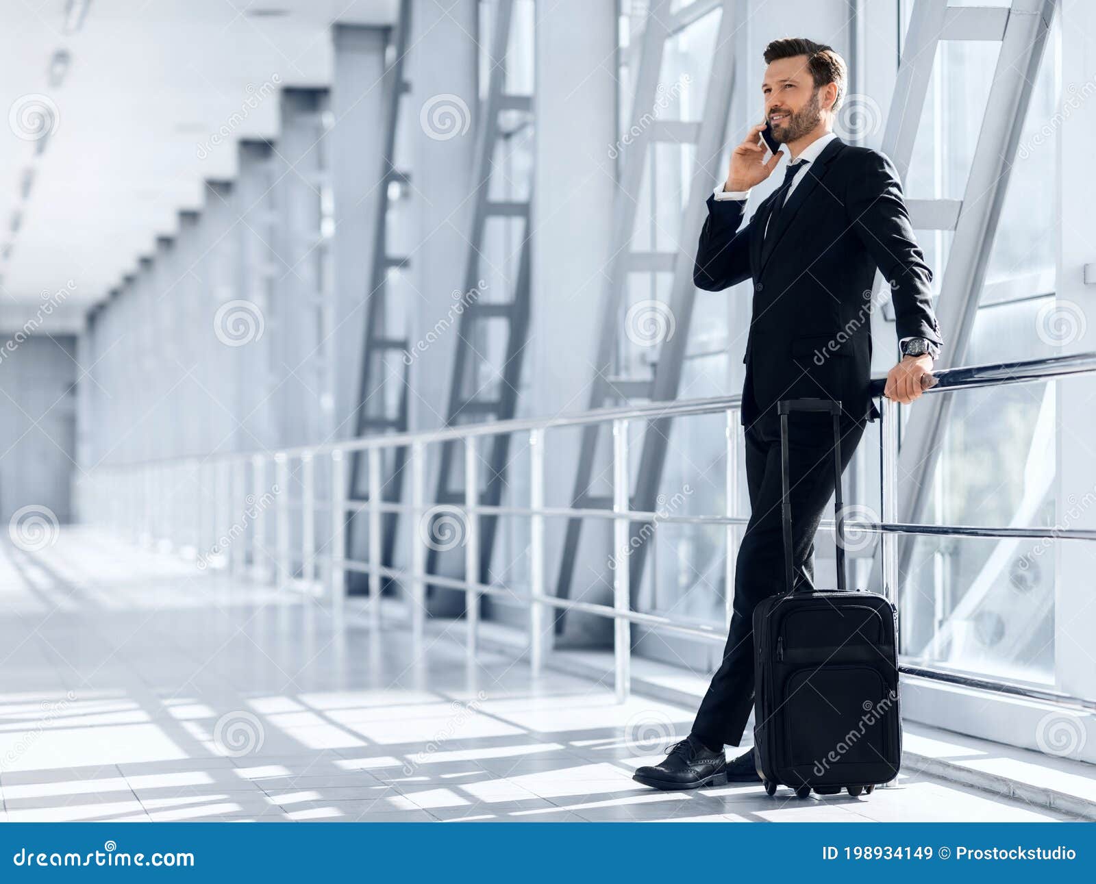 Happy Wealthy Businessman Standing in Airport, Talking on Mobile Phone ... Happy Wealthy Businessman Standing in Airport, Talking on Mobile Phone ...