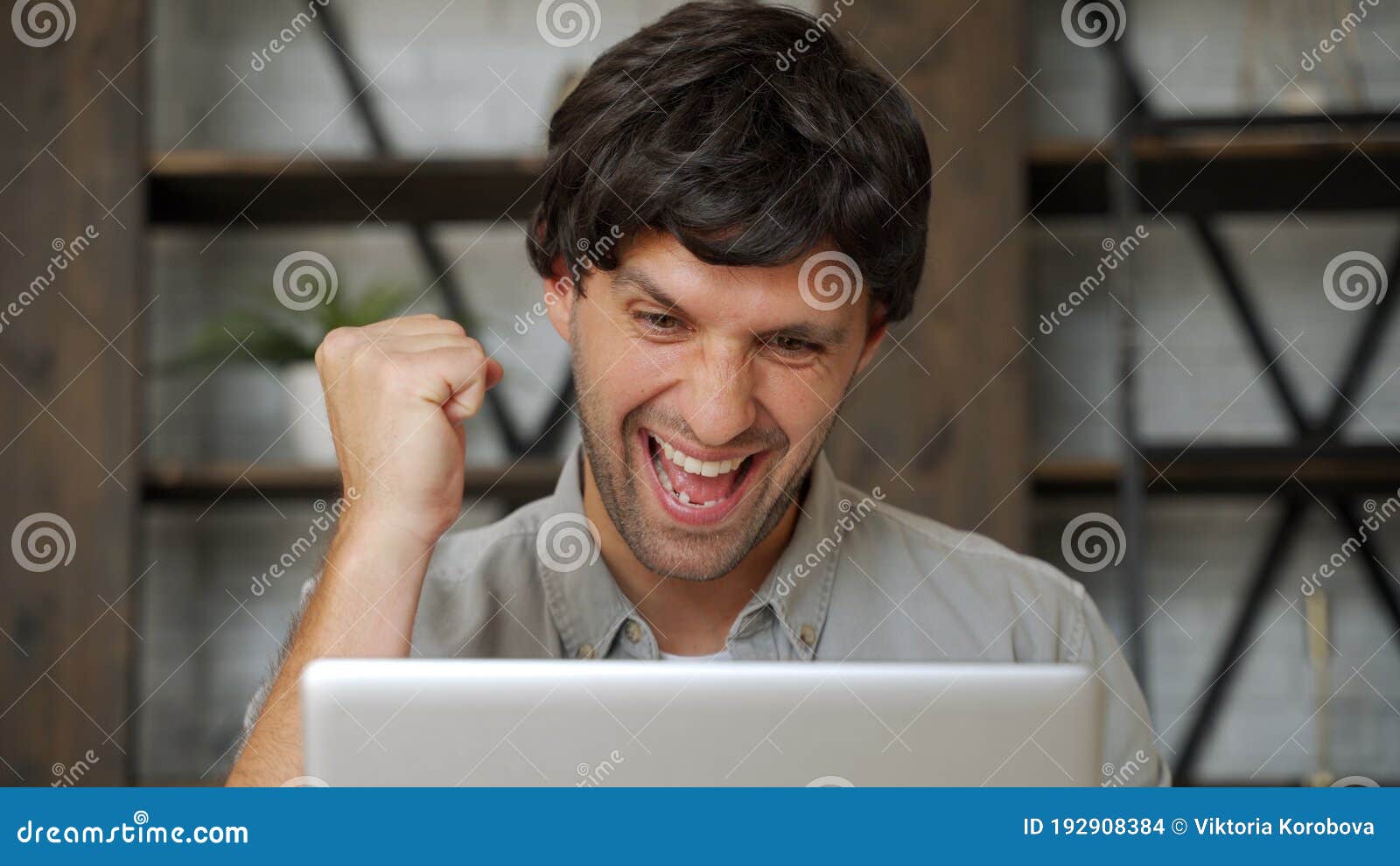 Happy Winner. Young Excited Man Using Laptop Computer while Sitting on ...