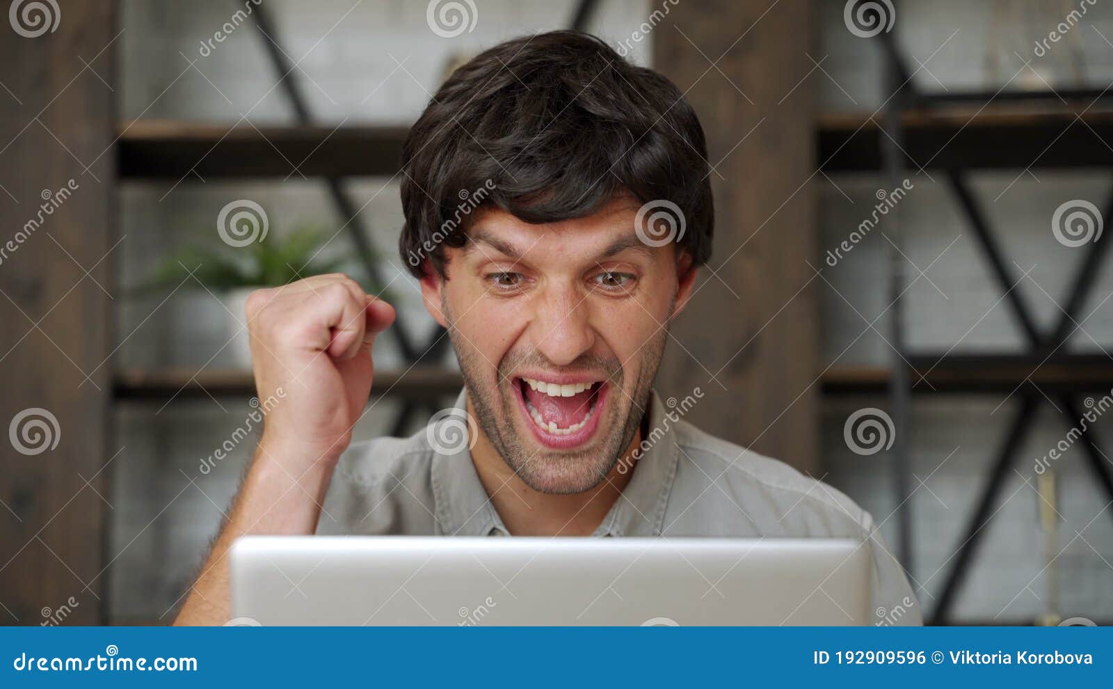 Happy Winner. Young Excited Man Using Laptop Computer while Sitting on ...