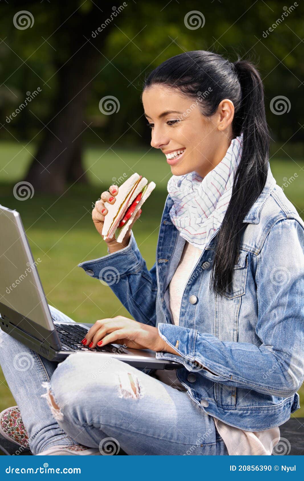 Happy Woman Browsing Internet in Park Eating Stock Photo - Image of ...