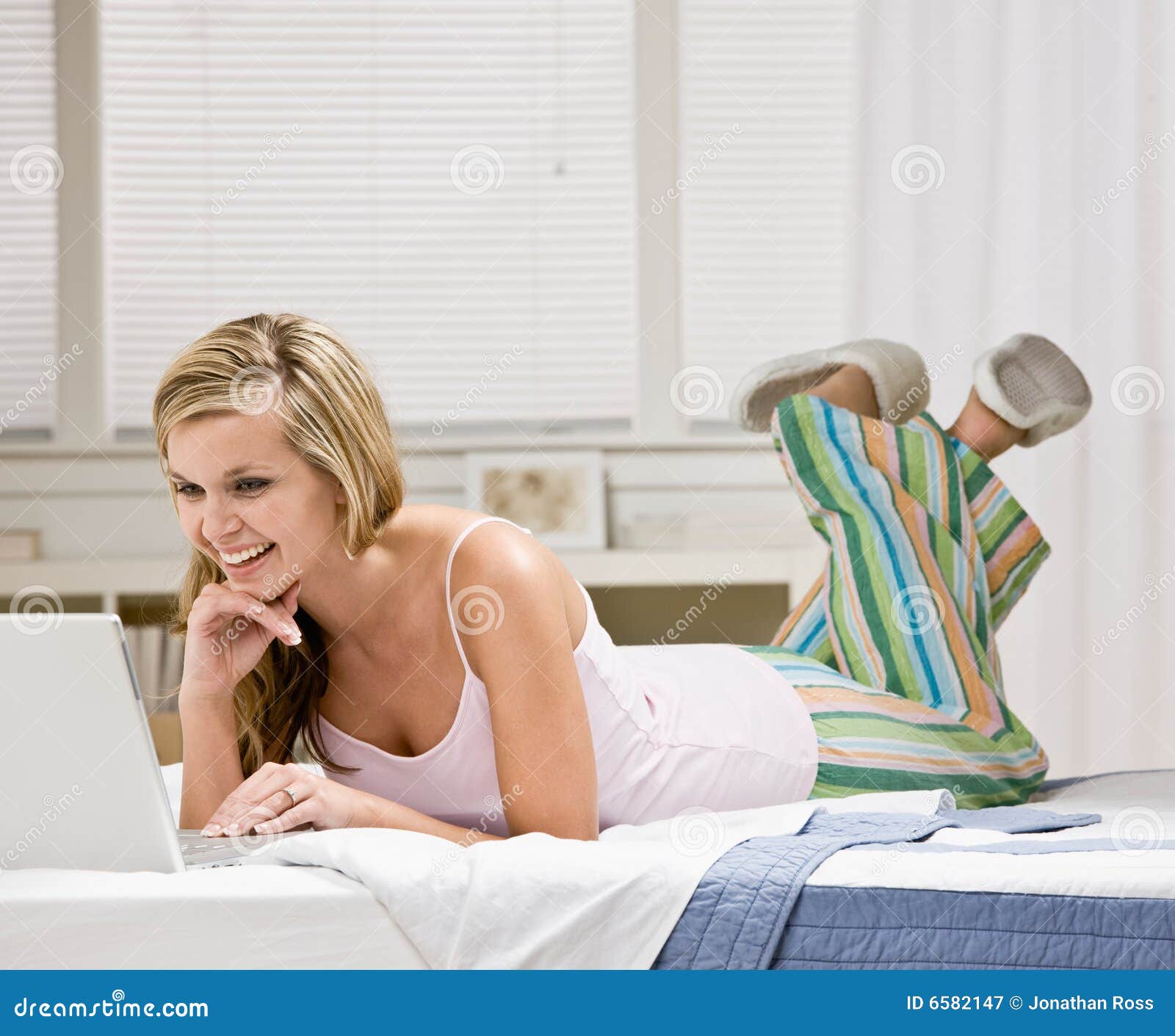 Happy Woman Laying on Bed in Bedroom Using Laptop Stock Image - Image ...