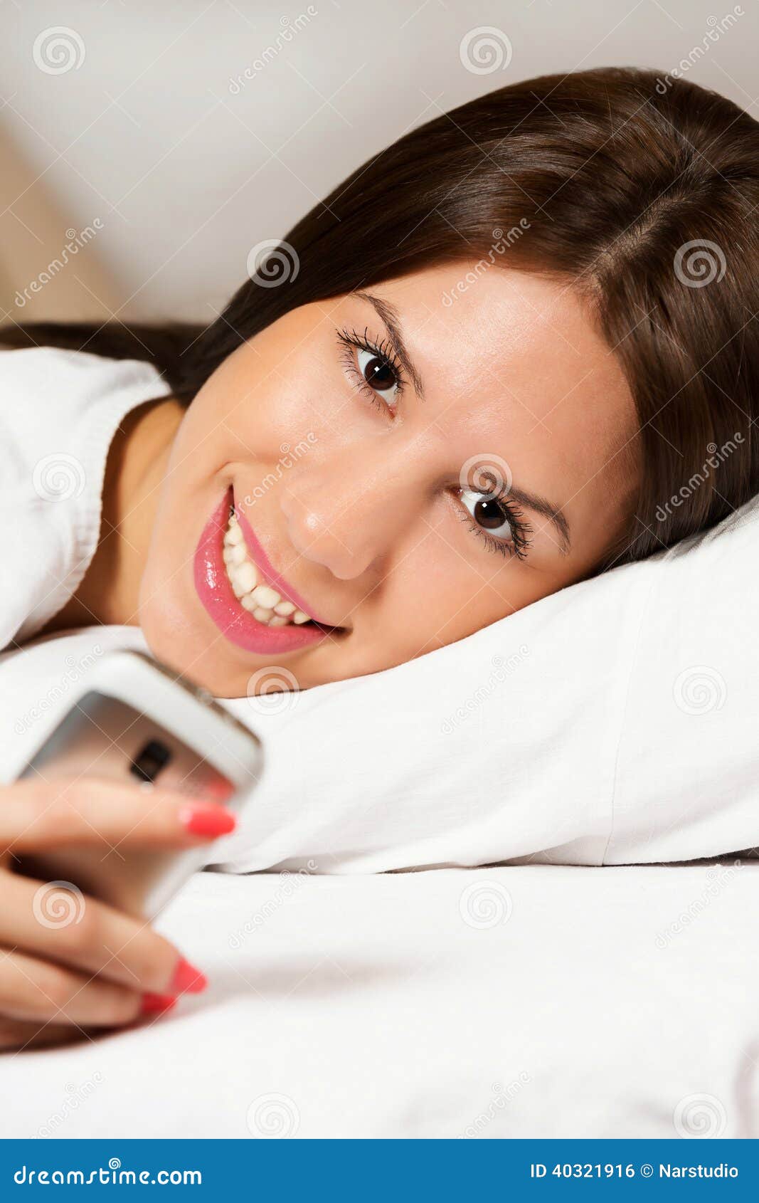Happy Woman Lying on Bed Smiling, Reading a Text Message Stock Photo ...