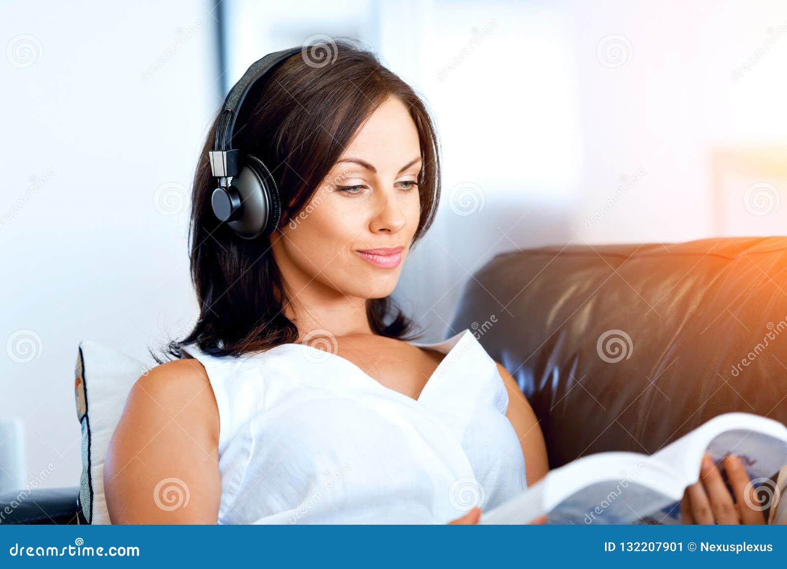 Happy Woman Reading A Book Sitting On A Sofa Stock Image Image Of