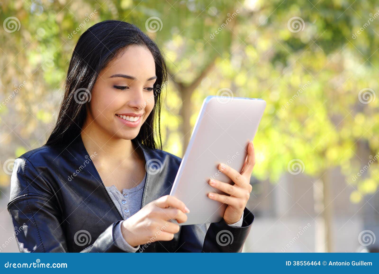 Happy Woman Reading a Tablet Reader in a Park Stock Photo - Image of ...