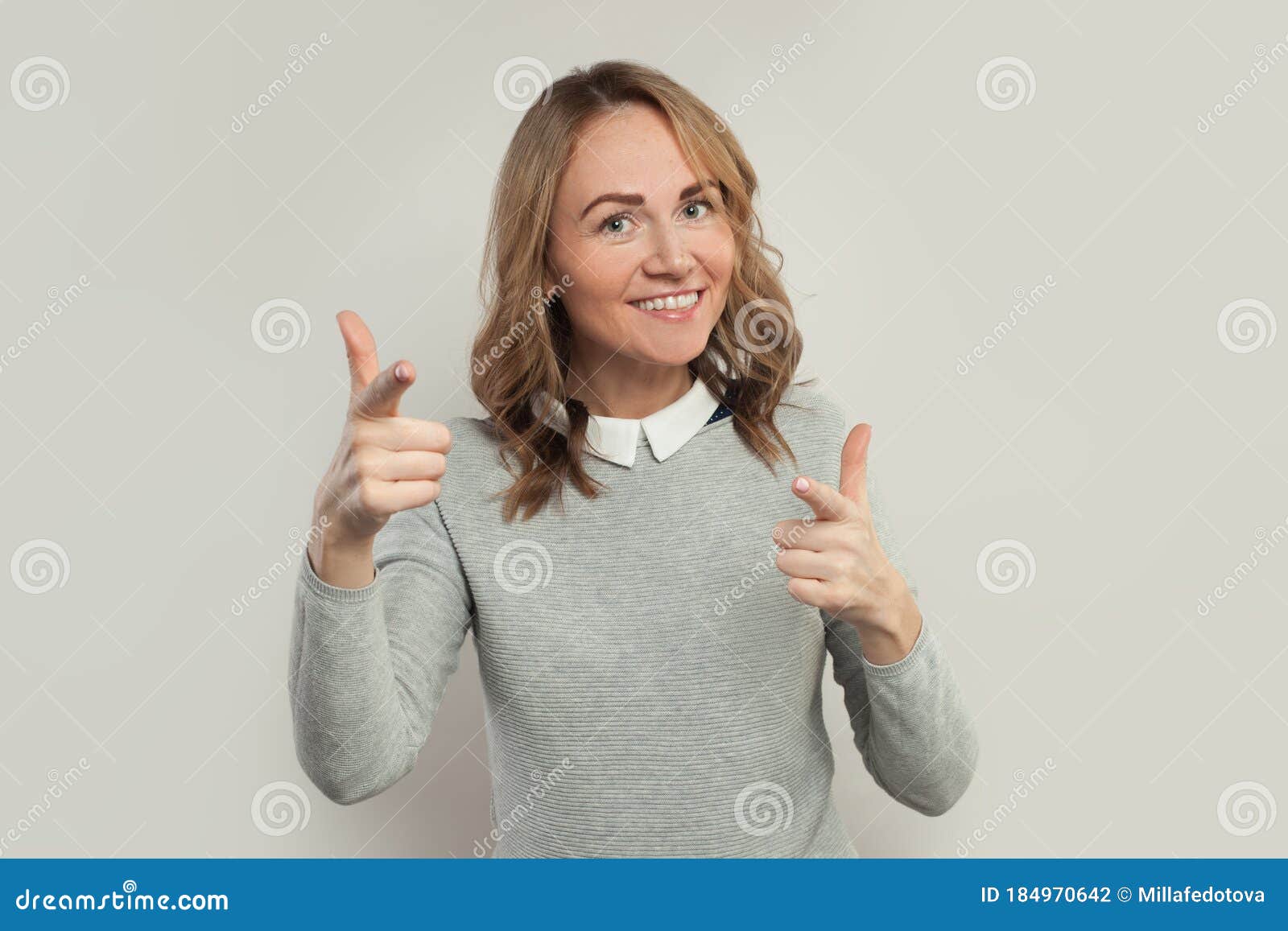Happy Woman Smiling and Pointing on White Background Stock Photo ...