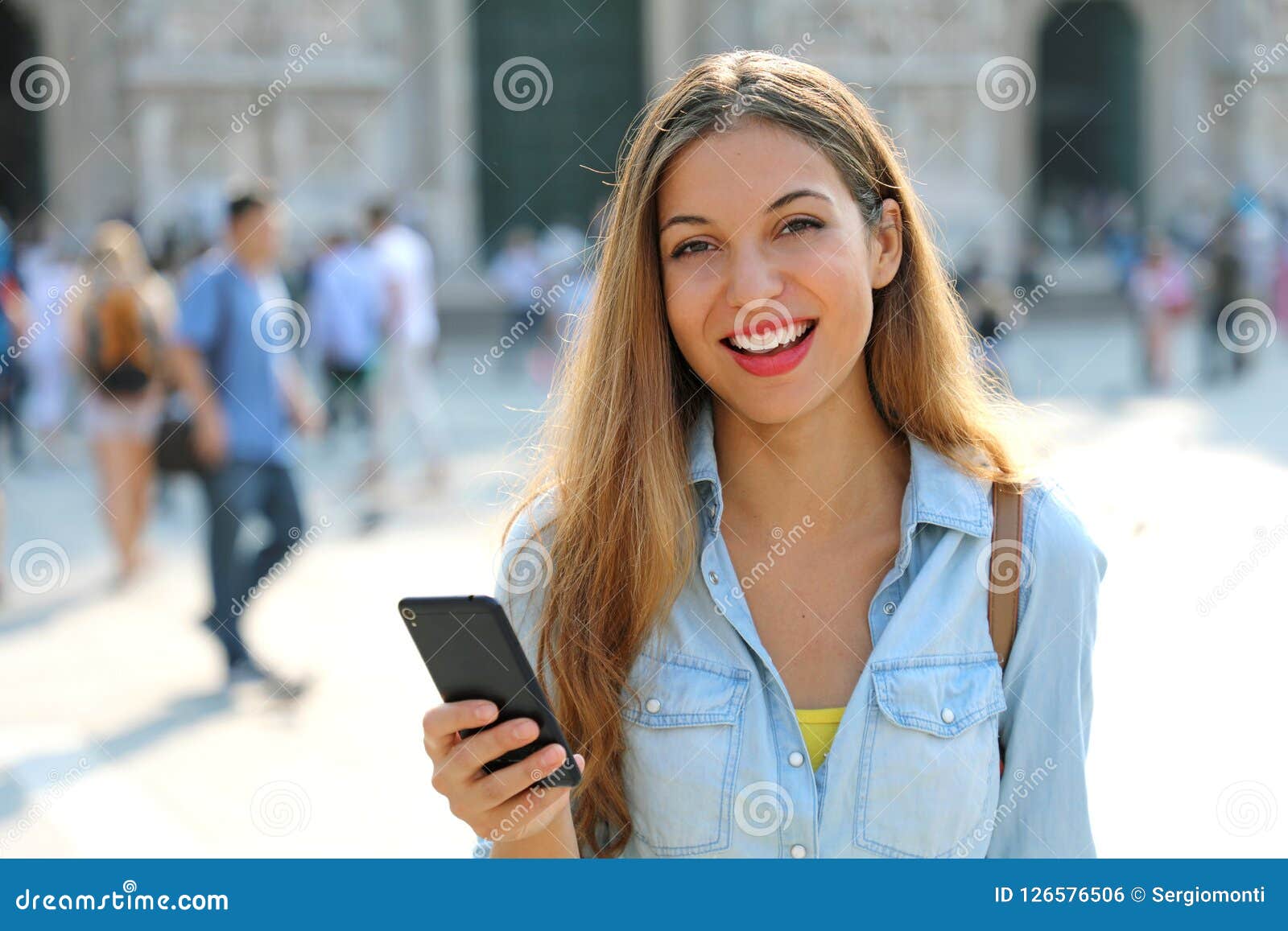 Happy Woman Smiling and Walking in the Street Using a Smartphone Stock ...