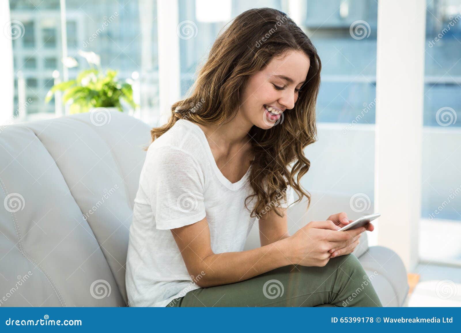 Happy Woman Texting on Sofa Stock Photo - Image of brunette, casual ...