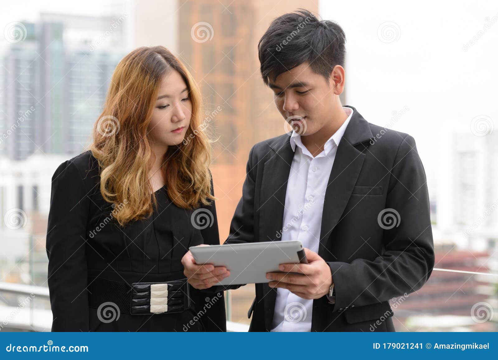 Happy Young Asian Business Couple Using Digital Tablet Together in the ... Happy Young Asian Business Couple Using Digital Tablet Together in the ...