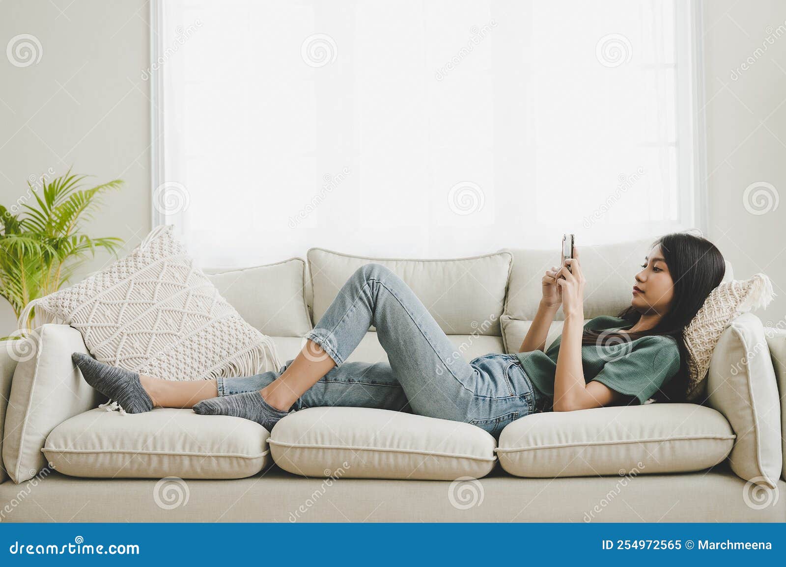 Happy Young Asian Woman Relaxing At Home She Is Lying Down On Sofa