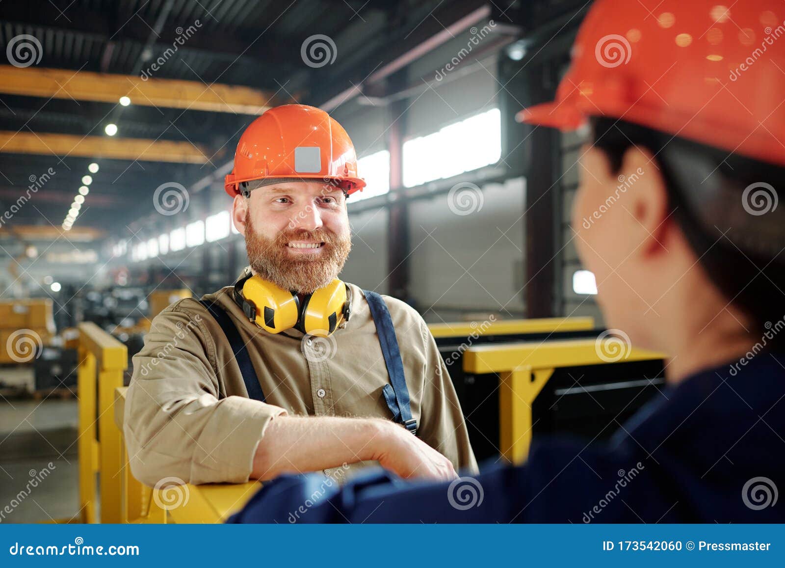 Happy Young Bearded Engineer in Hardhat Talking To His Colleague Stock ...