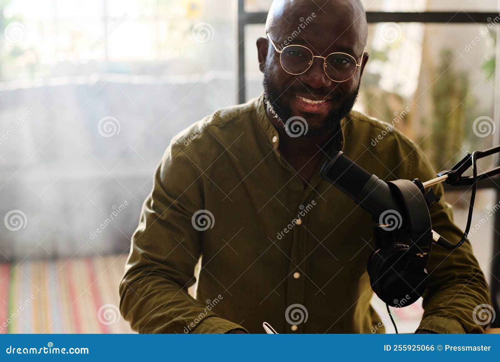 Happy Young Black Man Sitting in Front of Microphone and Looking at ...