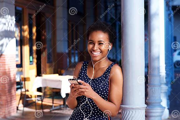 Happy Young Black Woman Listening To Music With Smart Phone And