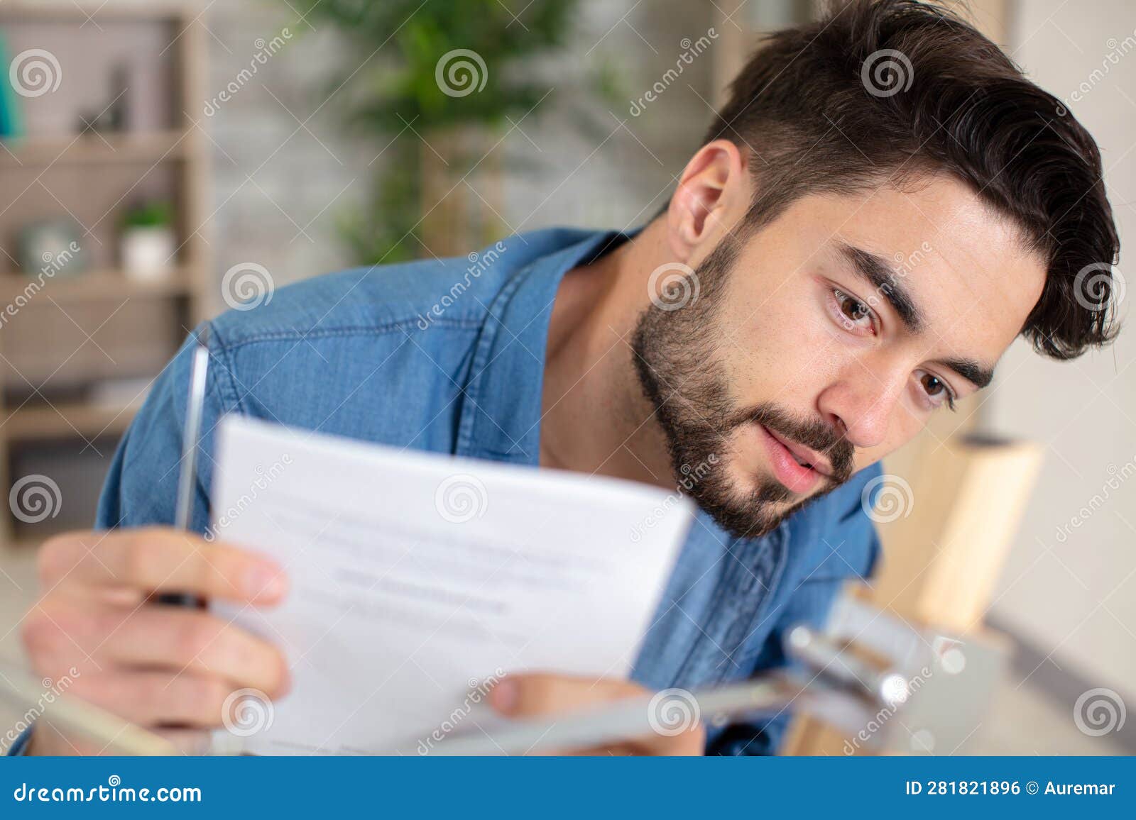 Happy Young Businessman Reading Paperwork at Desk in Office Stock Photo ...