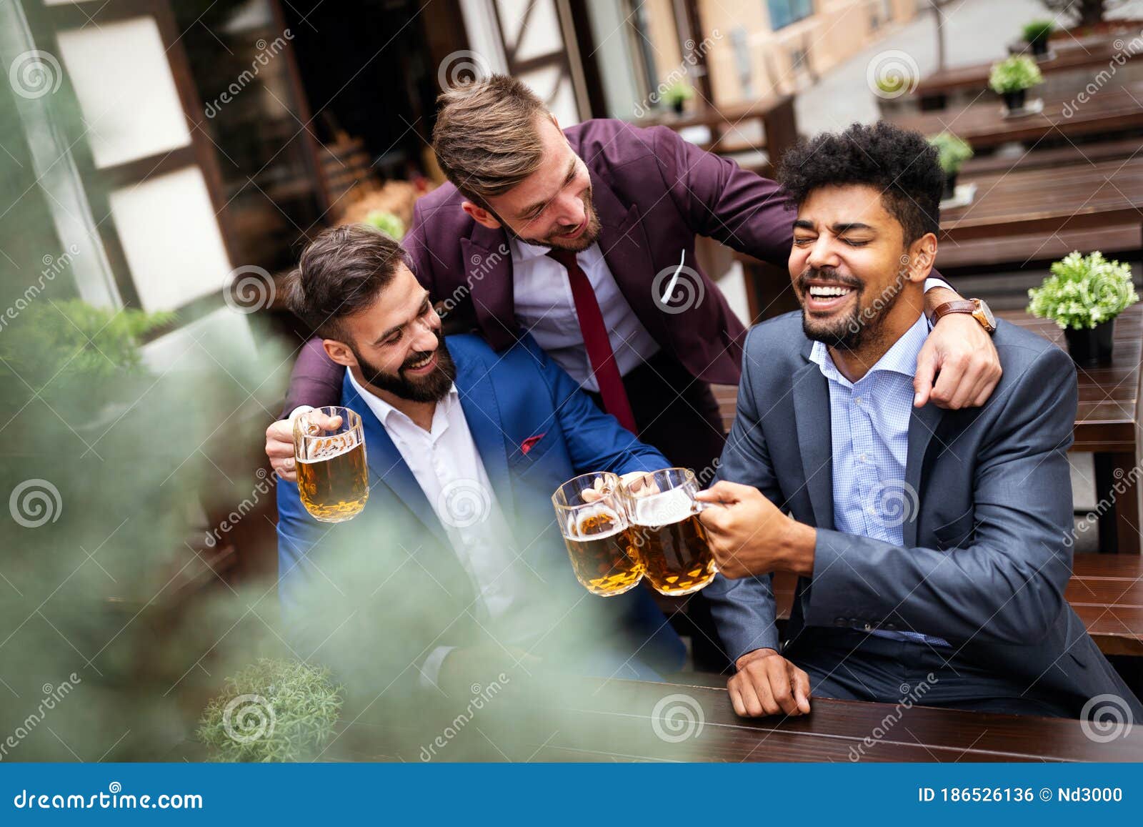 Happy Young Businessmen Drinking Beer and Talking at Pub after Work ...