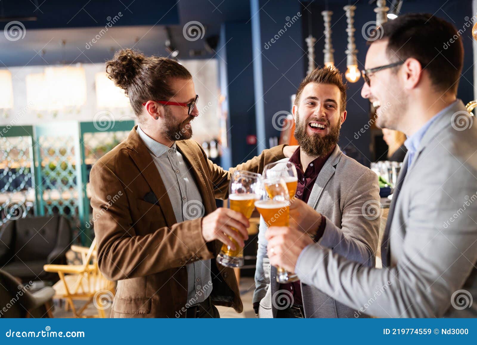 Happy Young Businessmen Drinking Beer and Talking at Pub after Work ...