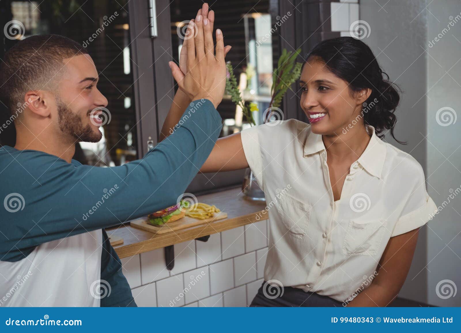 Couple Giving High-five in Cafe Stock Image - Image of relaxation ...