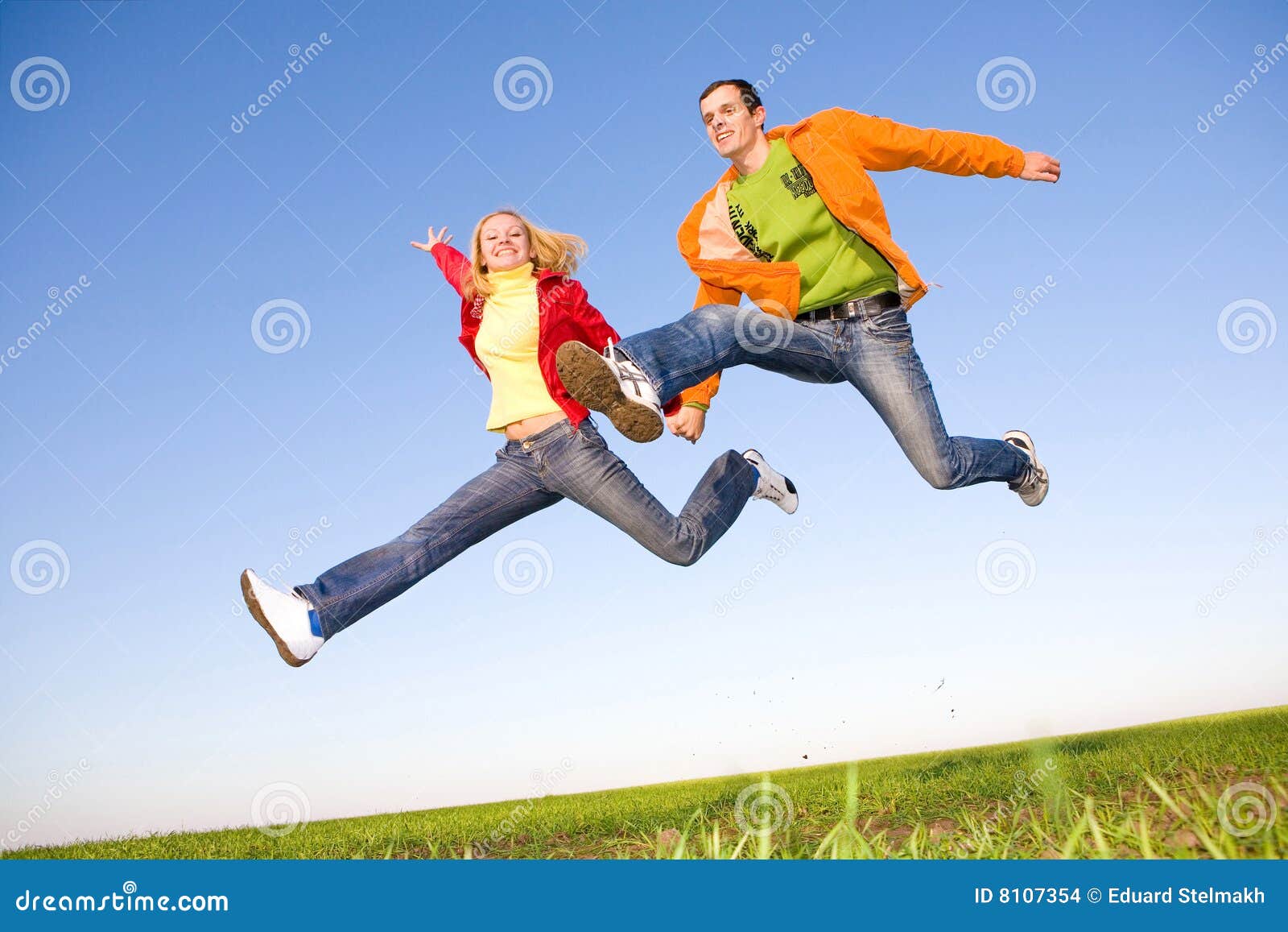 Happy young couple jumping stock photo. Image of student - 8107354