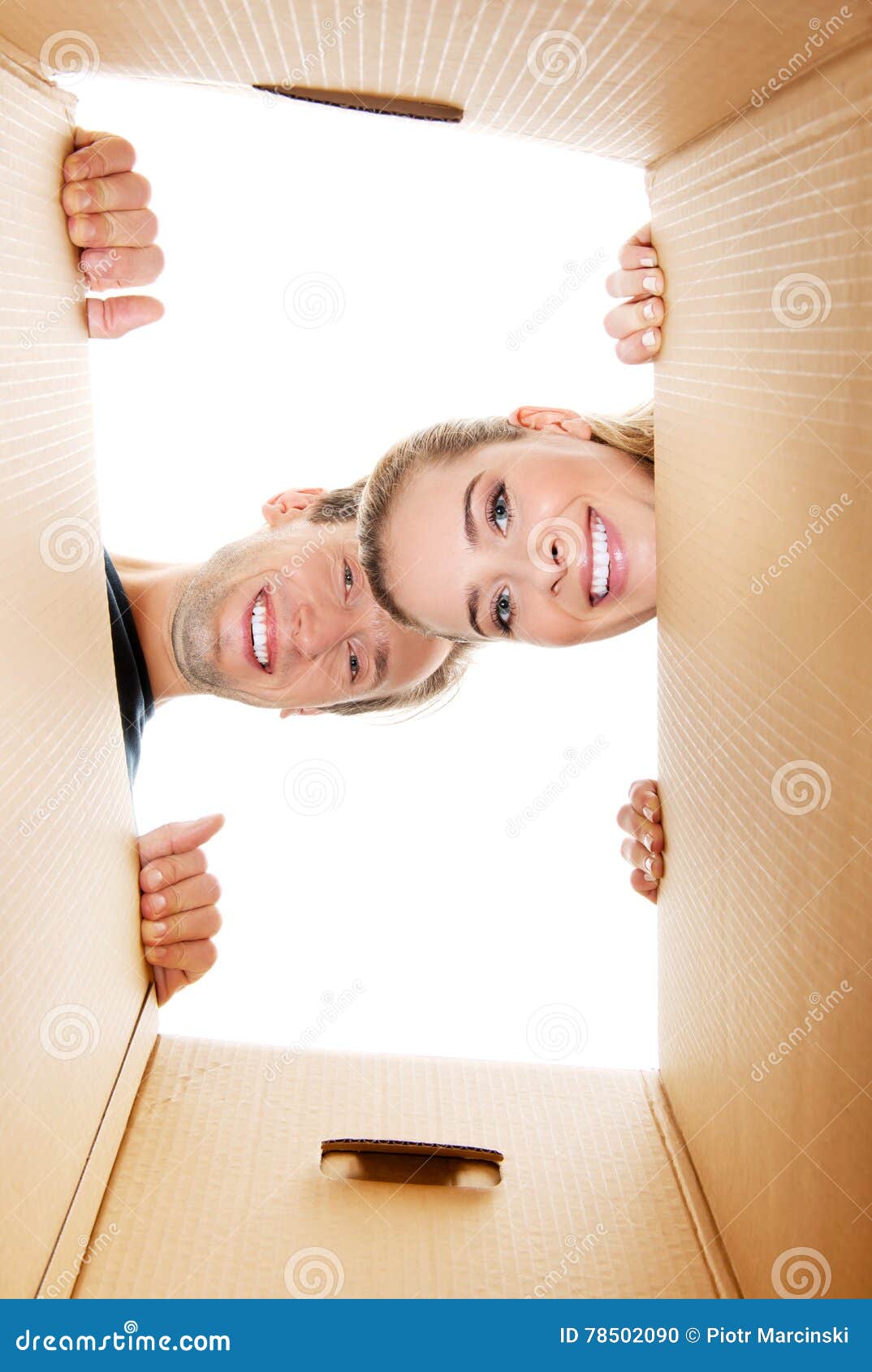 Happy Young Couple Opening a Carton Box and Looking Inside Stock Photo ...
