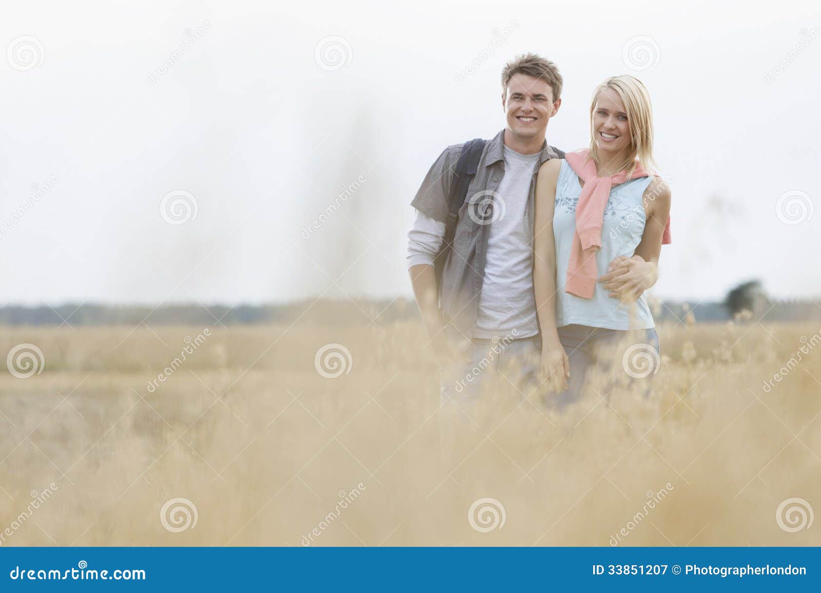 Happy Young Couple Standing at Field Stock Image - Image of clothing ...