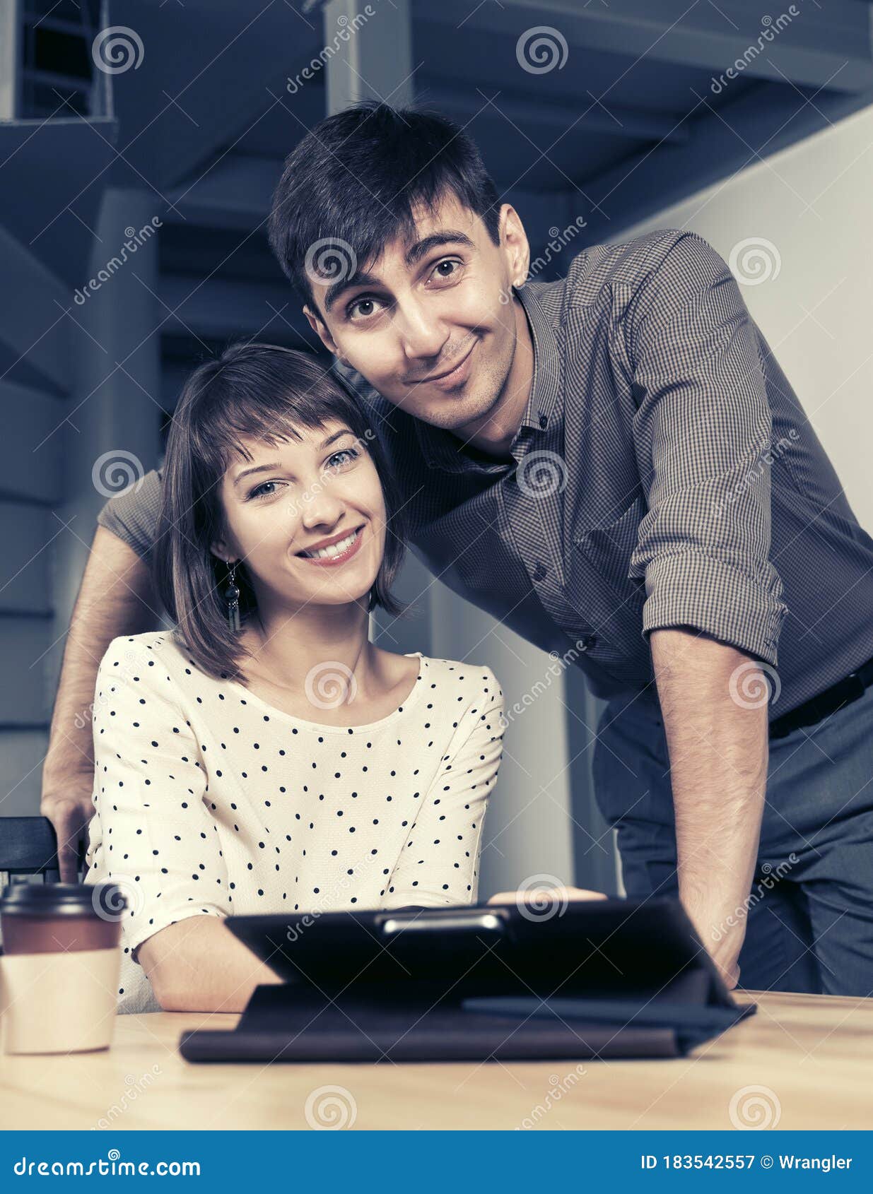 Happy Young Couple Using Digital Tablet Computer Sitting at the Table ...