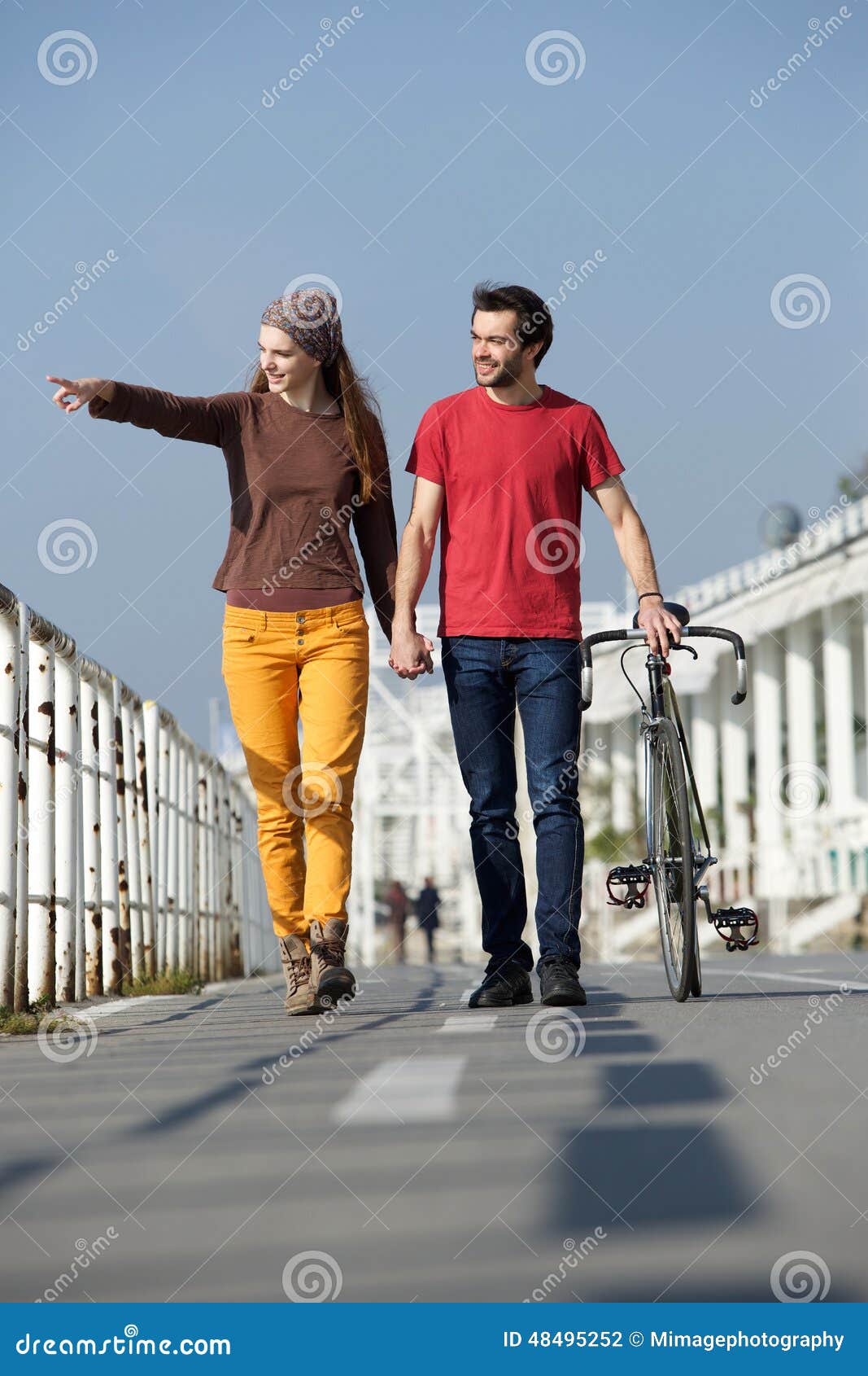 Happy Young Couple Walking Outdoors Pointing Stock Photo - Image of ...