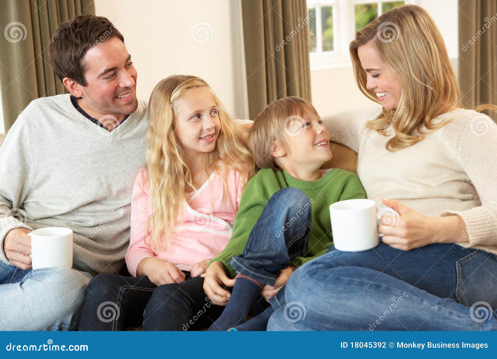 Happy Young Family Sitting and Talking on Sofa Stock Photo - Image of ...