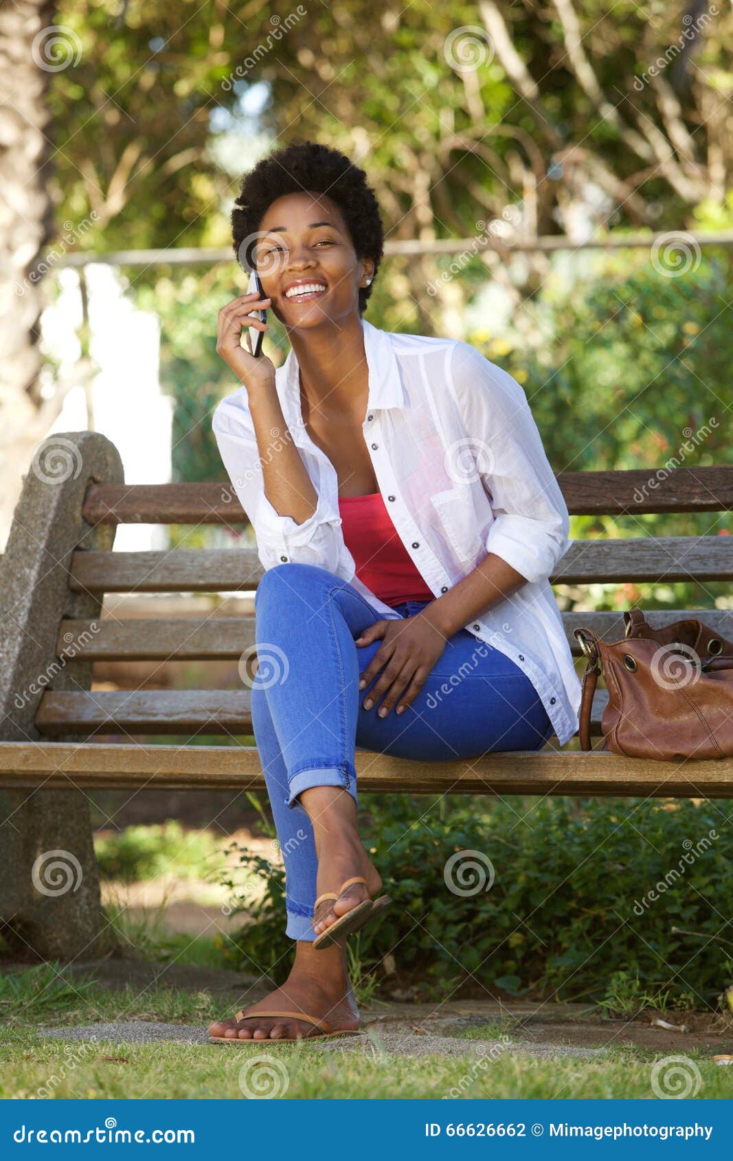 Happy Young Lady on a Park Bench and Using Mobile Phone Stock Photo ...
