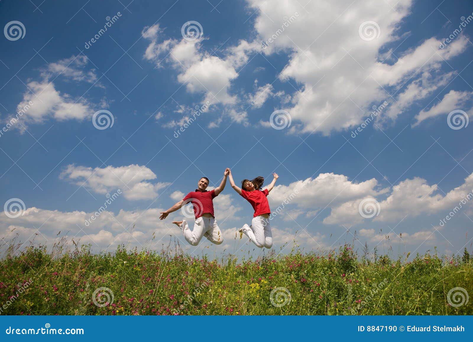 Happy Young Love Couple - Jumping Under Blue Sky Stock Photo - Image of ...