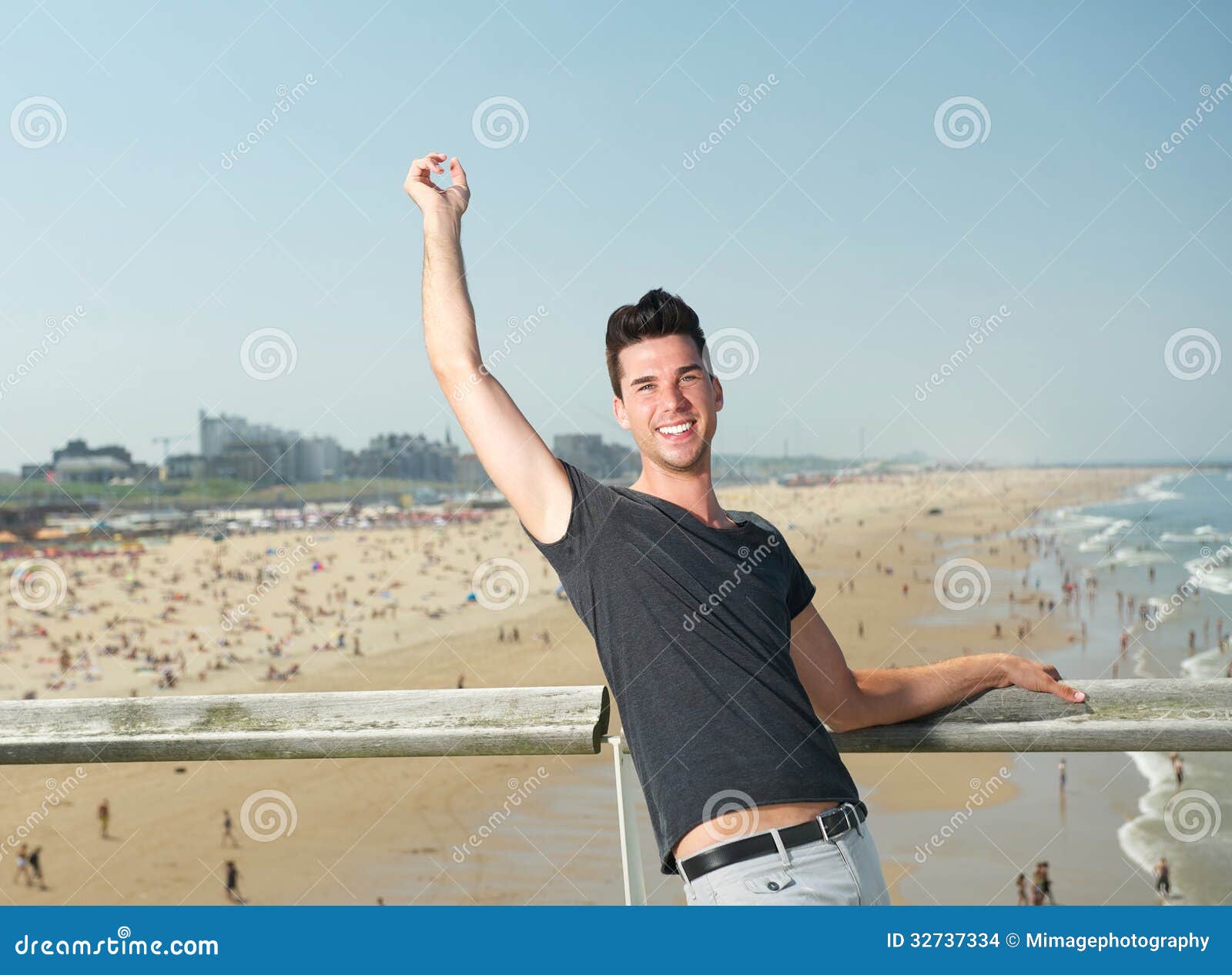 Happy Young Man with Arm Raised at the Seaside Stock Photo - Image of ...